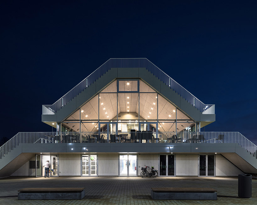 this sports center by NL architects features a pitched roof and grandstand