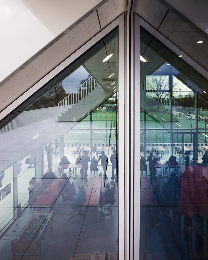 this sports center by NL architects features a pitched roof and grandstand