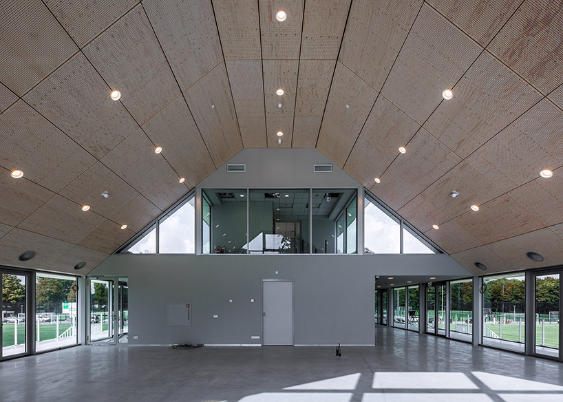 this sports center by NL architects features a pitched roof and grandstand
