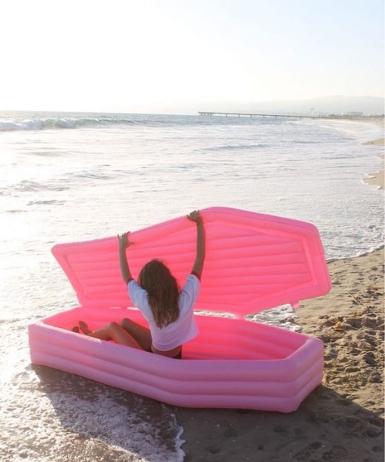 bury yourself this summer in this pink coffin float by pom pom