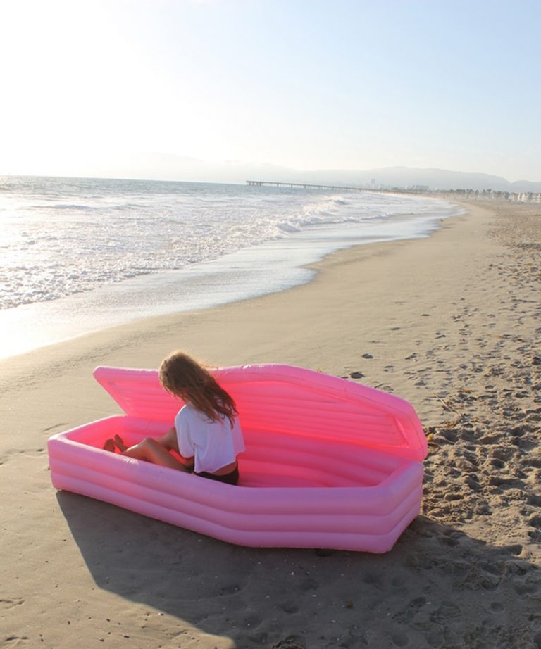bury yourself this summer in this pink coffin float by pom pom