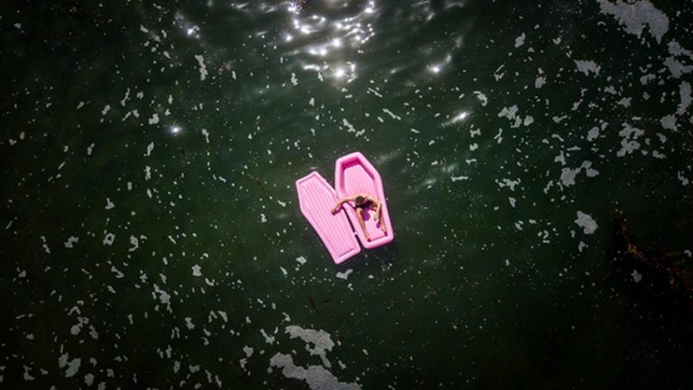 bury yourself this summer in this pink coffin float by pom pom