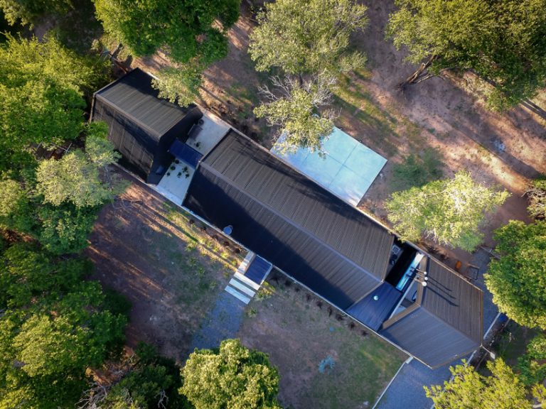 morini black house, 'la negrita,' is nestled among a forest in argentina
