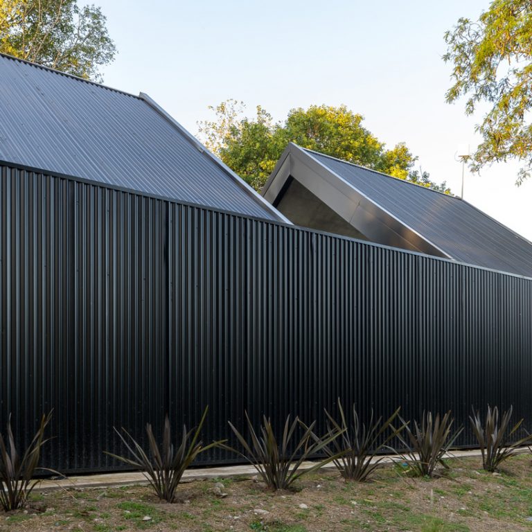 morini black house, 'la negrita,' is nestled among a forest in argentina