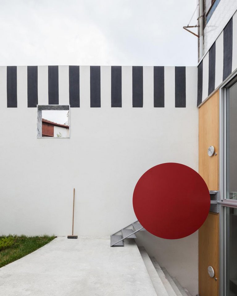fala atelier uses black + white stripes to frame 'uneven house' in porto