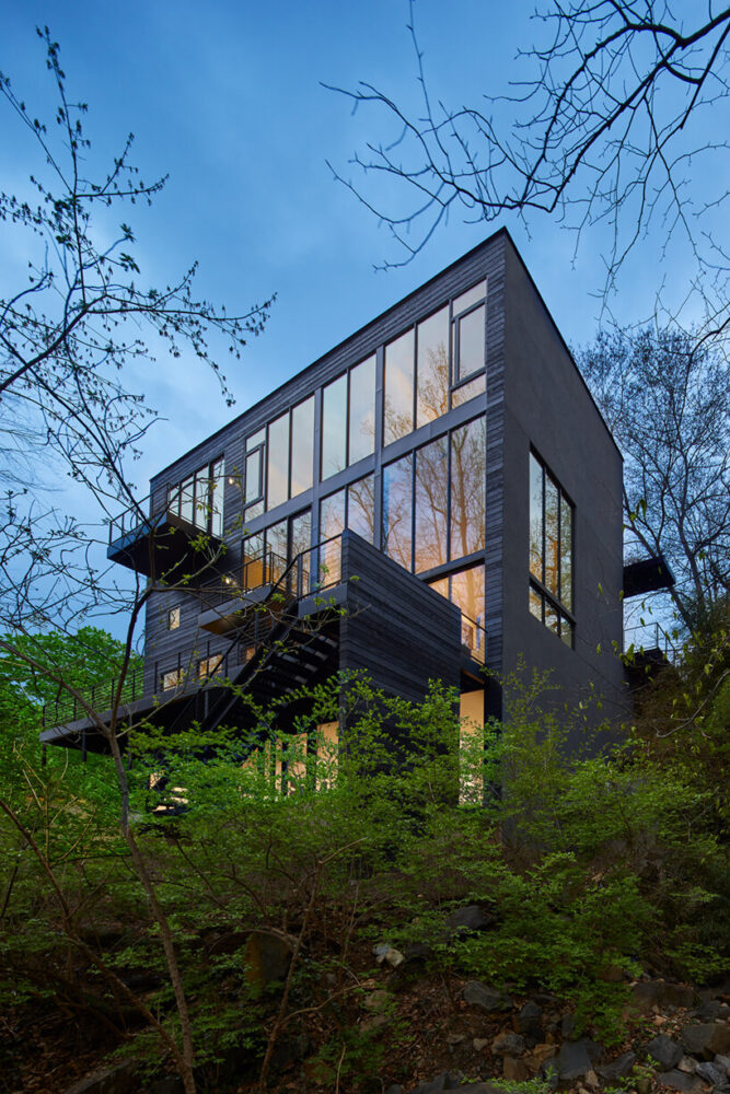 robert gurney architect's luminous facade opens toward its forested site