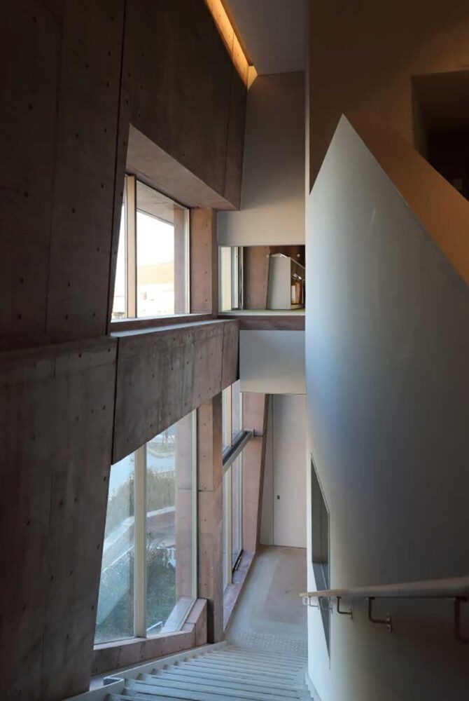 monolithic library extension by maru architecture floats on serene pond ...