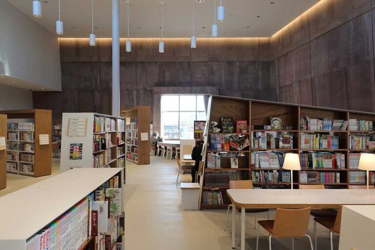 monolithic library extension by maru architecture floats on serene pond ...