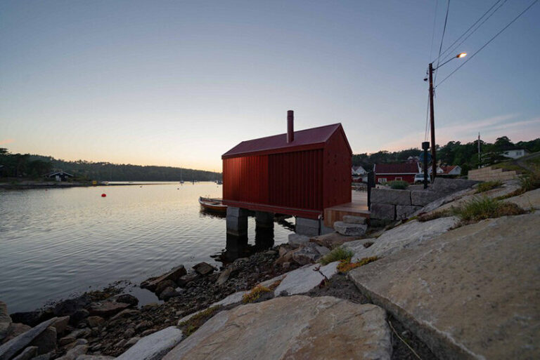 tiny red boathouse by handegård arkitektur settles in small norway harbor