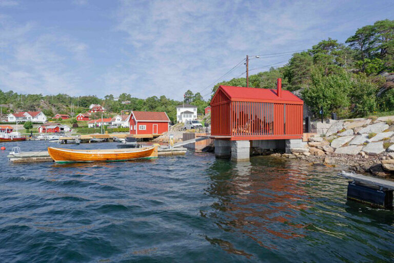 tiny red boathouse by handegård arkitektur settles in small norway harbor