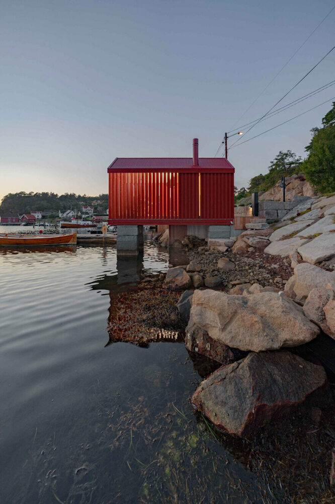 tiny red boathouse by handegård arkitektur settles in small norway harbor