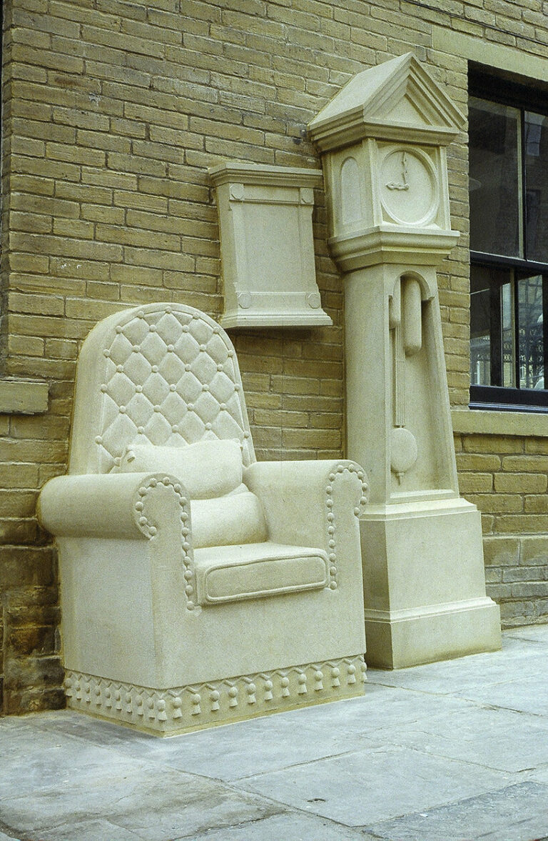 stone-carved grandad’s clock and chair by timothy shutter sit on a ...