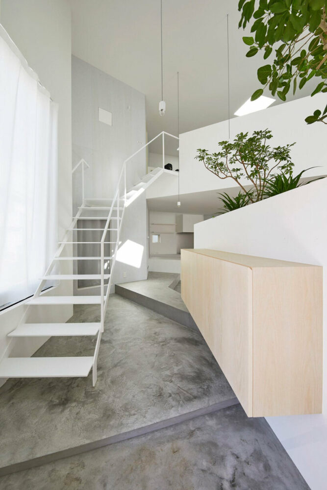 japanese residence by airhouse encloses minimalist interior of slanted ...