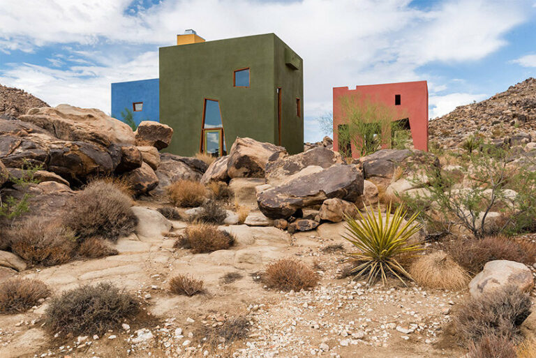emerging from the rugged joshua tree desert, colorful 'monument house ...