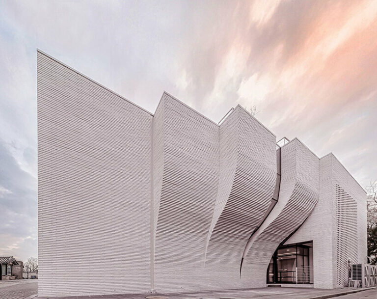 a curved brick wall ripples across LESS architects' office building ...