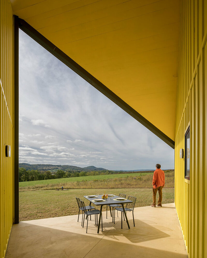 a dramatic yellow void defines 'oblong farm' by scalar architecture