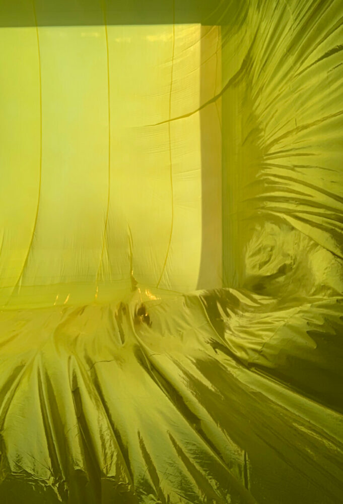 yellow inflatable installation squeezes into void space in barcelona