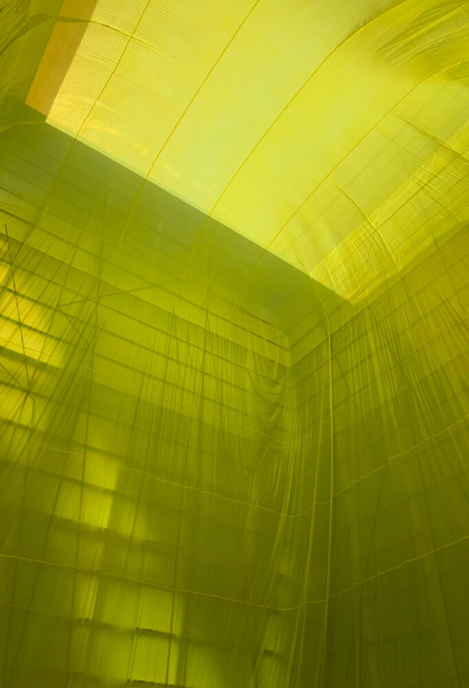 yellow inflatable installation squeezes into void space in barcelona