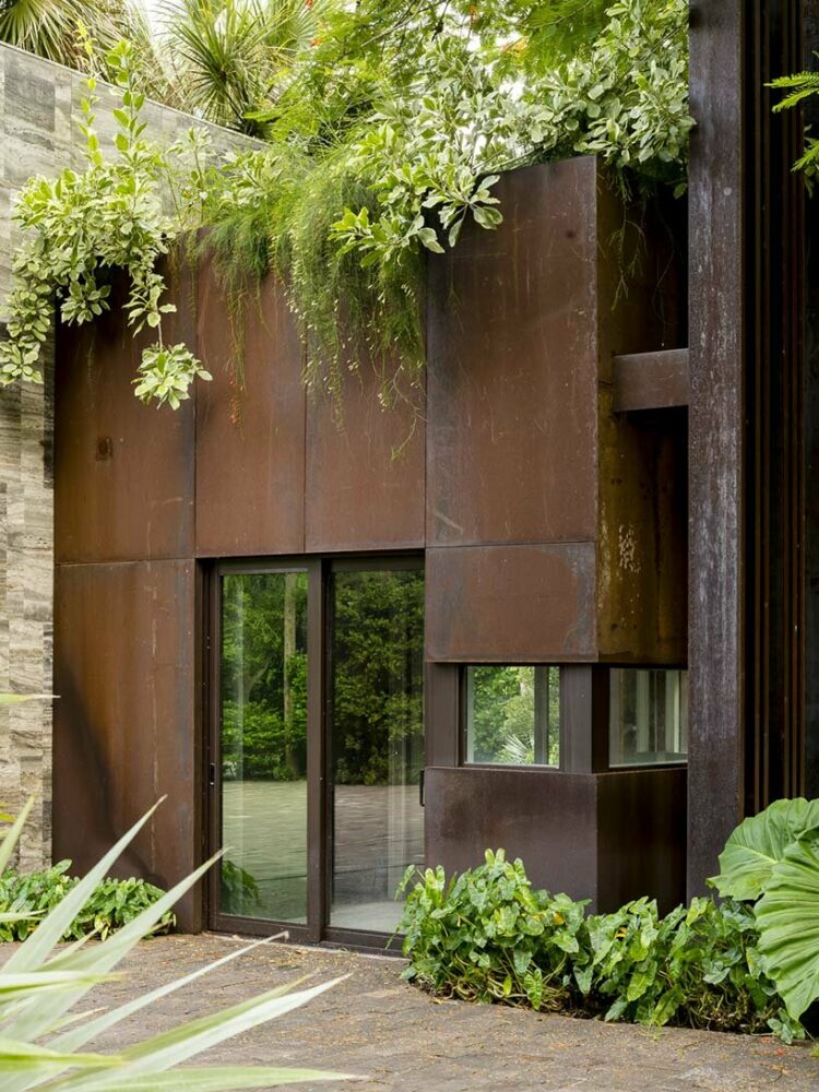 corten steel gatehouse overgrown by tropical nature in coconut grove, miami