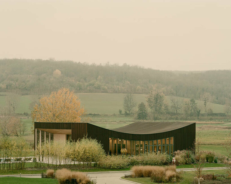 wellness pavilion with curved roof echoes contours of natural landscape ...
