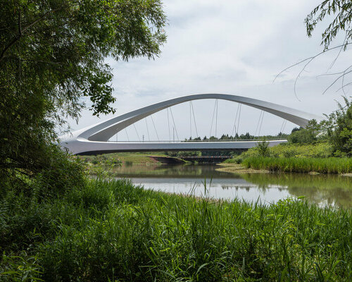 sleek concrete pedestrian bridge spans the vltava river in prague