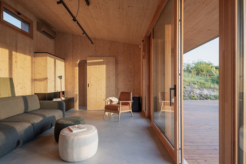 hello wood's CLT house gently peeks out amid rural flora in hungary