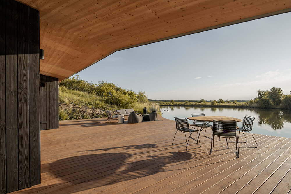 hello wood's CLT house gently peeks out amid rural flora in hungary