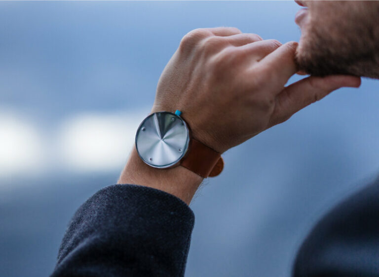 steel watch without hour markers vibrates to tell how many minutes passed