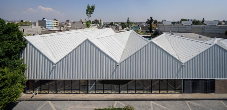 metallic roof shapes triangular folds atop cultural infrastructure in ...