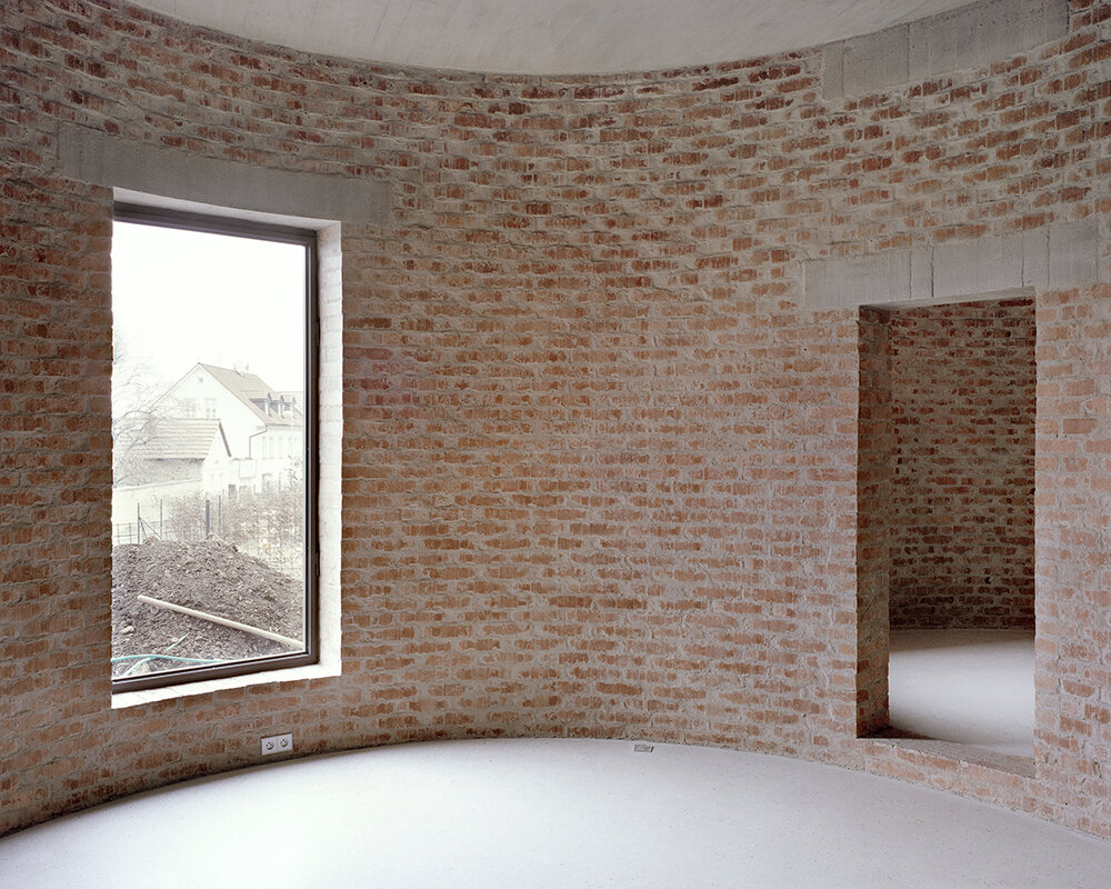 christian kerez's house okamura unfolds as circular brick columns in ...