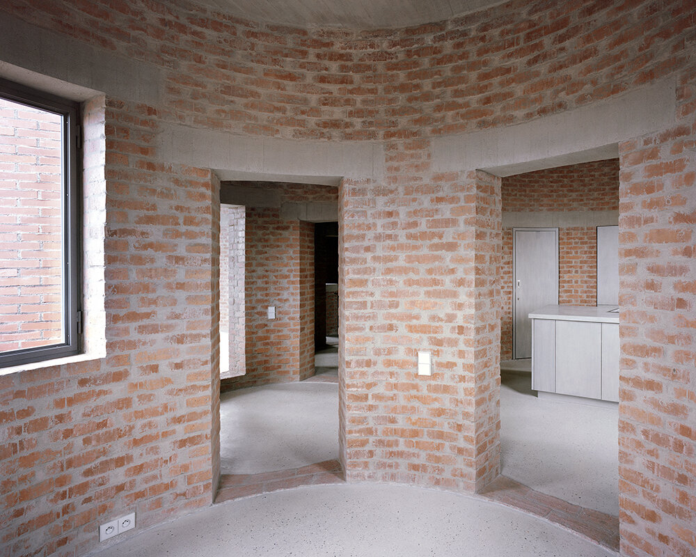 christian kerez's house okamura unfolds as circular brick columns in ...
