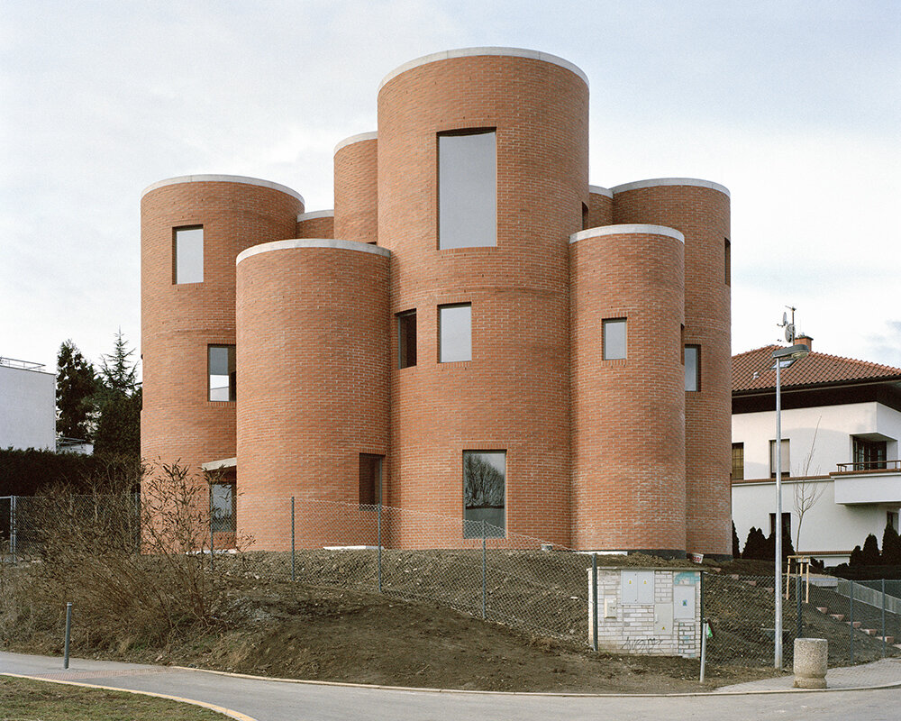 christian kerez's house okamura unfolds as circular brick columns in ...