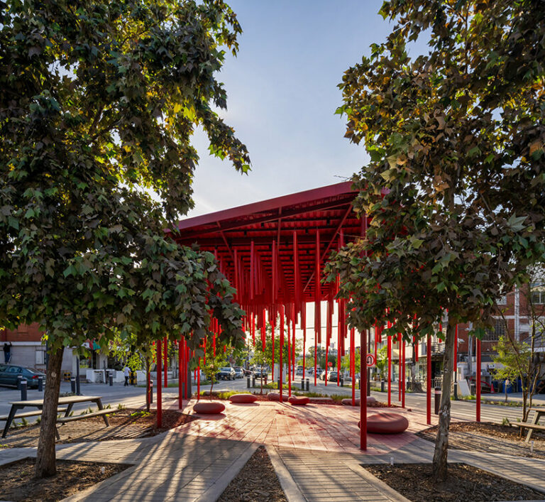 melodic pvc tubes attract pedestrians inside red-painted pavilion in mexico