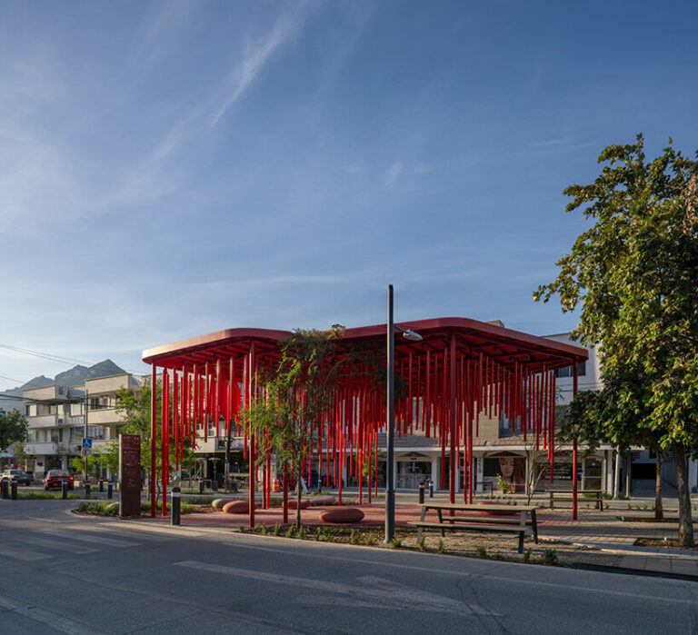 melodic pvc tubes attract pedestrians inside red-painted pavilion in mexico