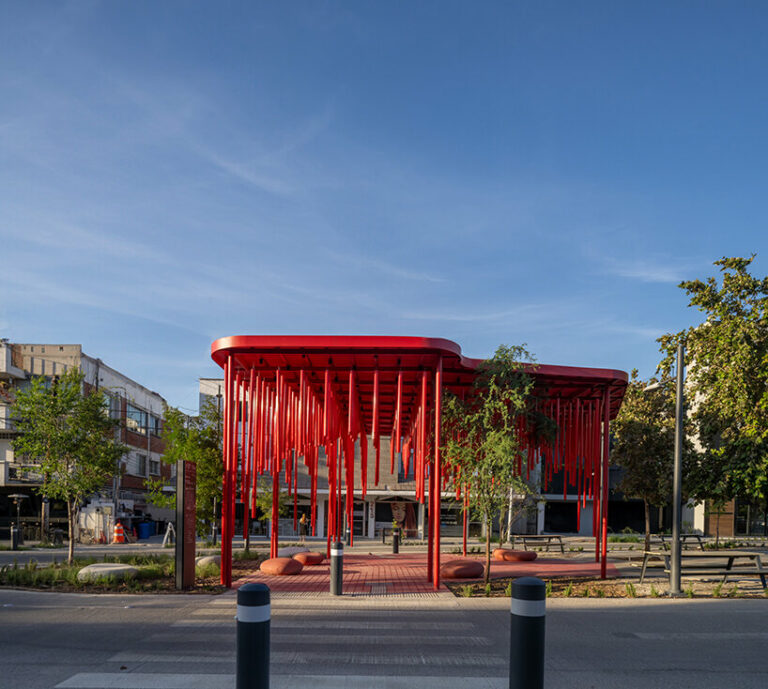melodic pvc tubes attract pedestrians inside red-painted pavilion in mexico