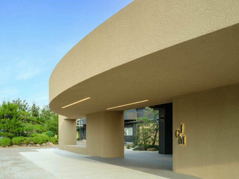 kubo tsushima architects sculpts earthy curved facade for renovated golf club in japan