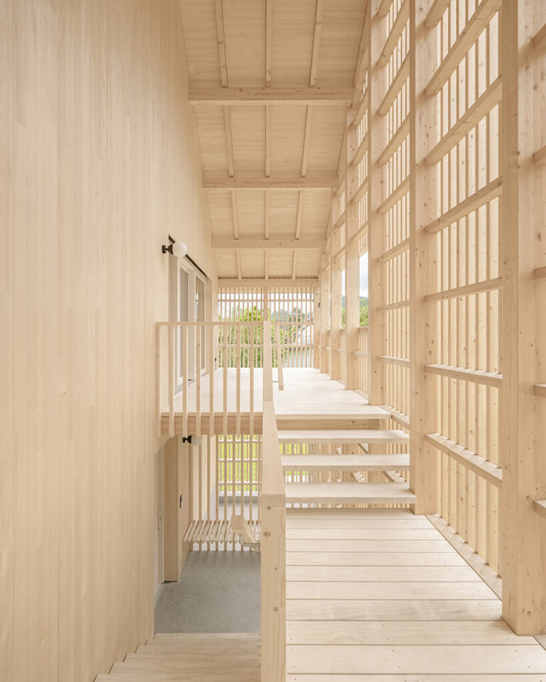 scalloped shingles and timber screens wrap modern home by MWarchitekten
