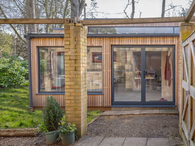 ceramic artist's wood-clad studio extends 80s-built house in the UK