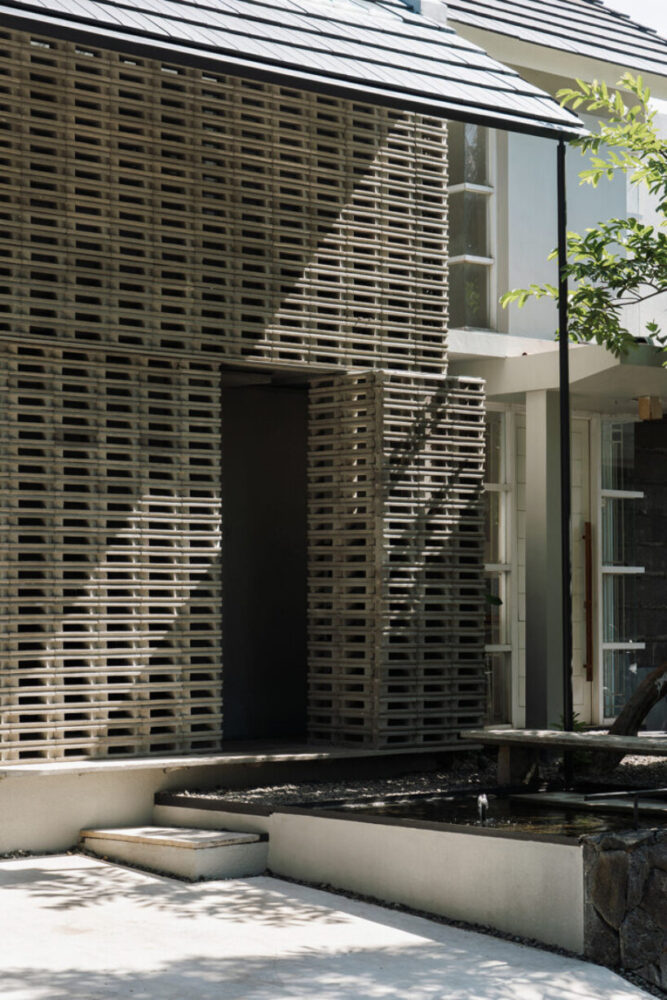 interlocking spaces behind perforated brick facade turn home into ...