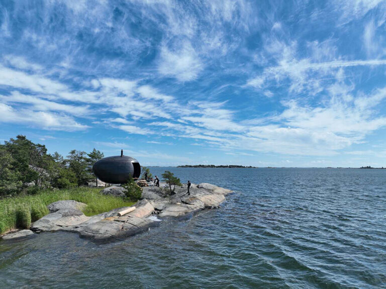 using curved wood, sotamaa crafts aerodynamic 'kivi sauna' in finland