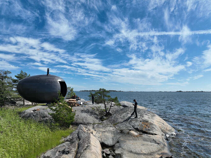 using curved wood, sotamaa crafts aerodynamic 'kivi sauna' in finland