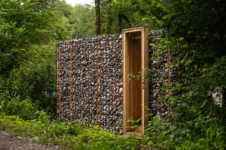 gabion walls frame tephra's stone shelter along dry riverbed in french ...