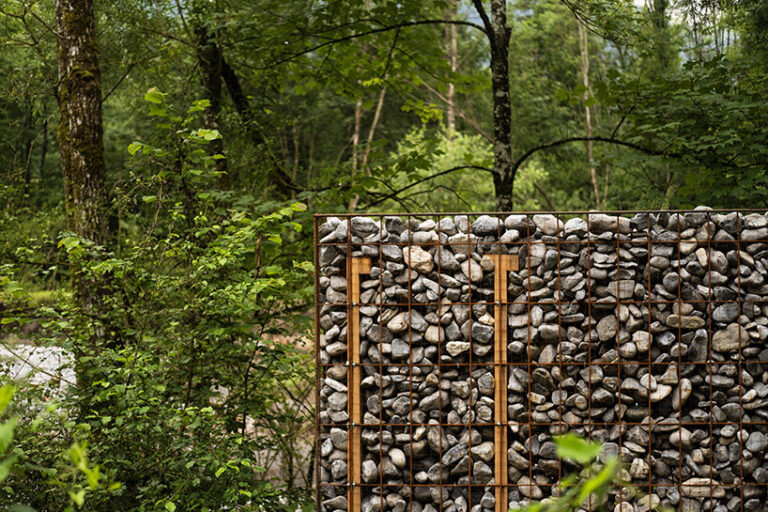 gabion walls frame tephra's stone shelter along dry riverbed in french ...