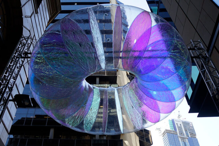 floating oculus installation shimmers in shifting chromatic light